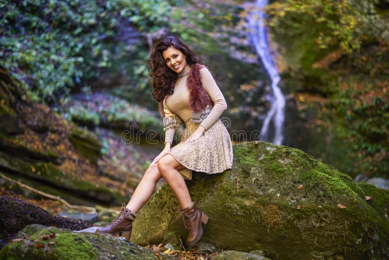 A Beautiful Woman Sitting by a Waterfall in Different Positions Stock ...