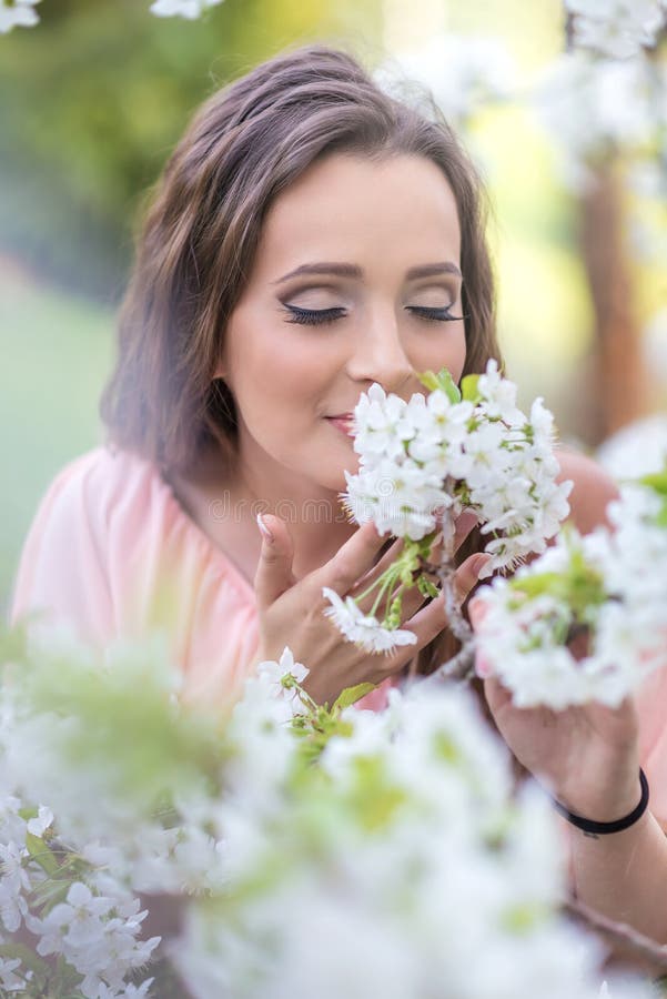 Beautiful Woman Smelling a Flower Stock Image - Image of eyes, outdoor ...