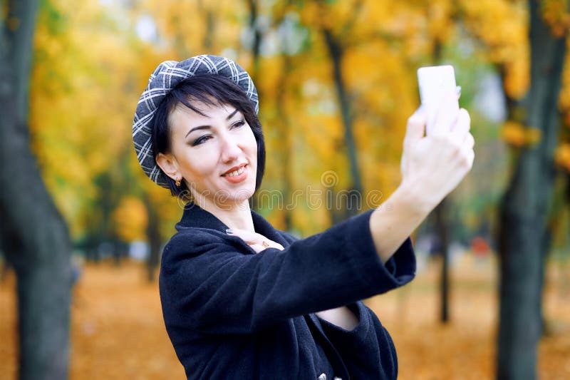 Beautiful Woman Taking Selfie By Smartphone And Having Fun In Autumn