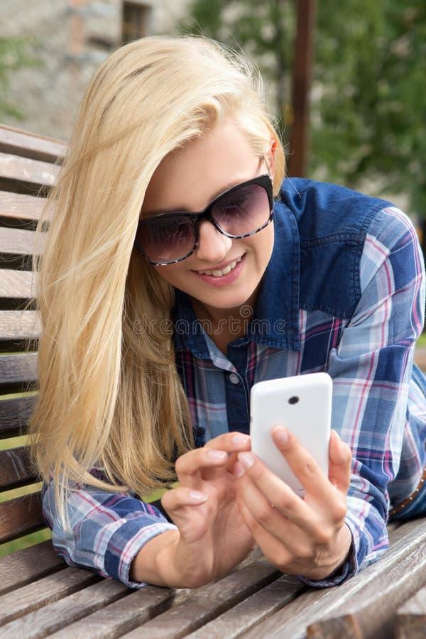 Beautiful Woman Texting with Her Phone on Bench in Park Stock Photo ...