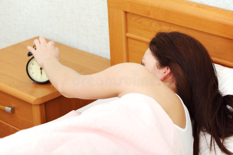Beautiful Woman Turning Off an Alarm Clock. Stock Photo - Image of ...