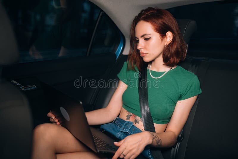 Beautiful Woman is Using Laptop while Sitting on Back Seat Stock Photo ...