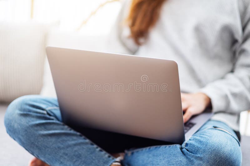 A Beautiful Woman Using And Working On Laptop Computer While Sitting On