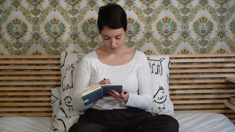 Beautiful Woman is Writing Notes on Her Notebook. Stock Video - Video ...