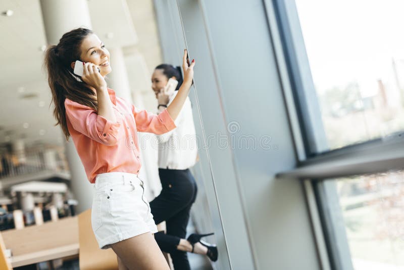 Beautiful Women Using Phones and Talkin during Break Stock Photo ...