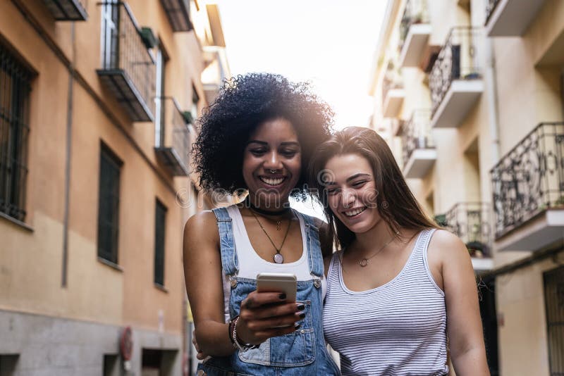 Beautiful Women Using a Mobile in the Street. Stock Image - Image of ...