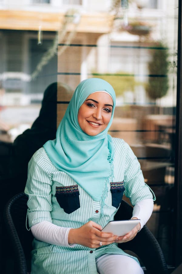 Beautiful Young Arabic Girl In Hijab Posing For A Camera At Street Cafe