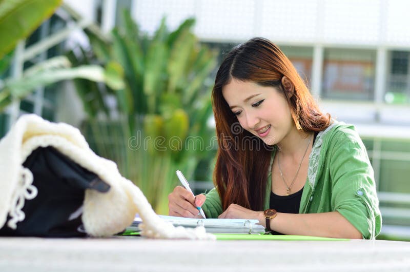 Beautiful Young Asian Student is Reading and Writing Stock Image ...