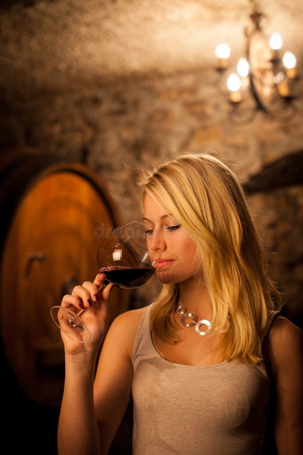 Beautiful Young Blond Woman Tasting Red Wine in a Wine Cellar Stock ...