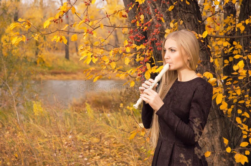 Beautiful Young Blonde Woman Playing Flute Recorder in Autumn Forest ... Beautiful Young Blonde Woman Playing Flute Recorder in Autumn Forest ...