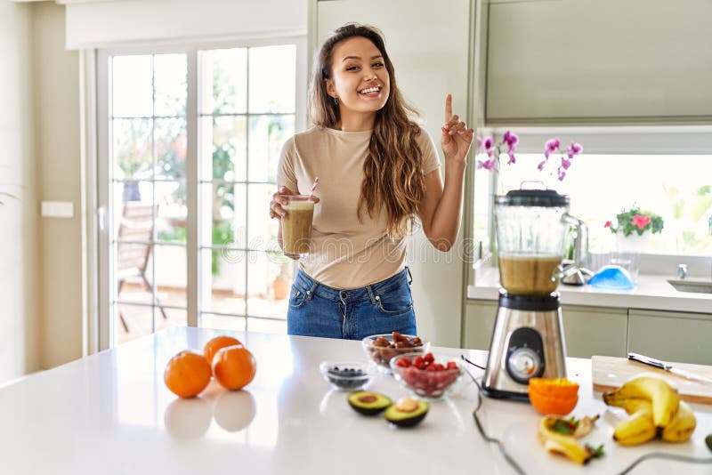 Beautiful Young Brunette Woman Drinking Glass Of Smoothie At The