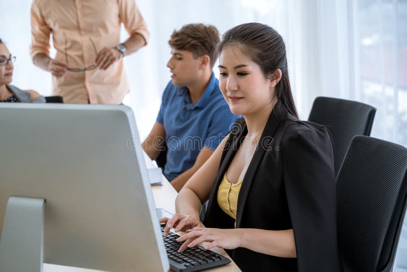 A Beautiful Young Businessman is Using a Computer To Work within the ...