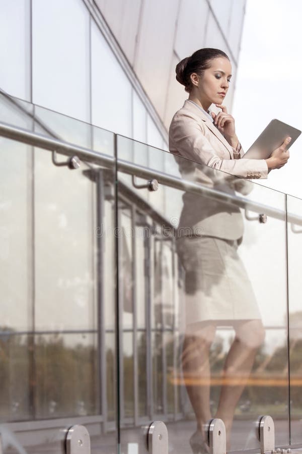 Beautiful Young Businesswoman Using Digital Tablet at Office Railing ...