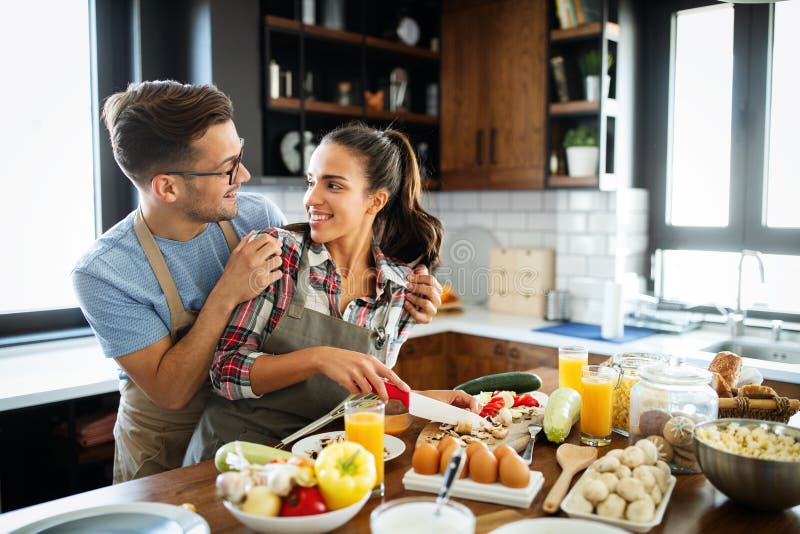 Beautiful Young Couple Having Fun in the Kitchen while Cooking. Stock ...