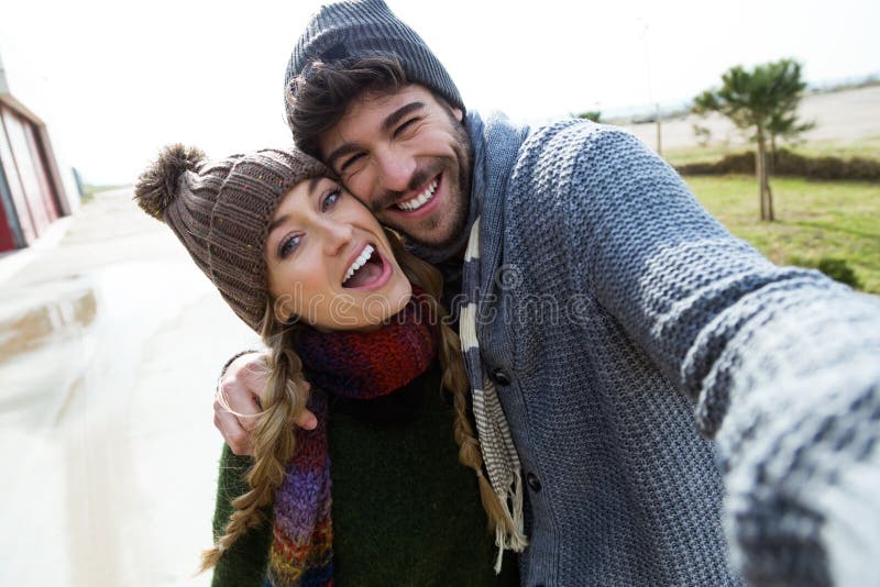 Beautiful Young Couple Using Mobile Phone in a Cold Winter on Th Stock ...