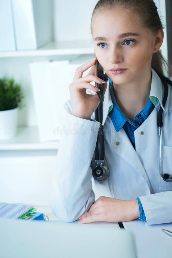 Beautiful Young Female Doctor Sitting in Front of Working Table with ...