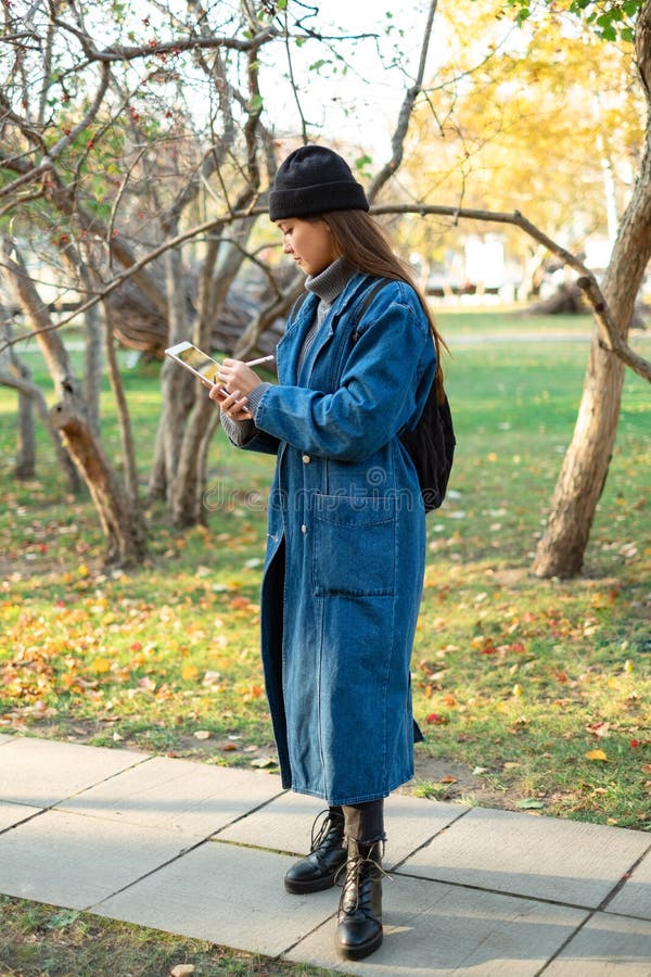 Beautiful Young Female Student is Studying Using a Tablet in a Park ...