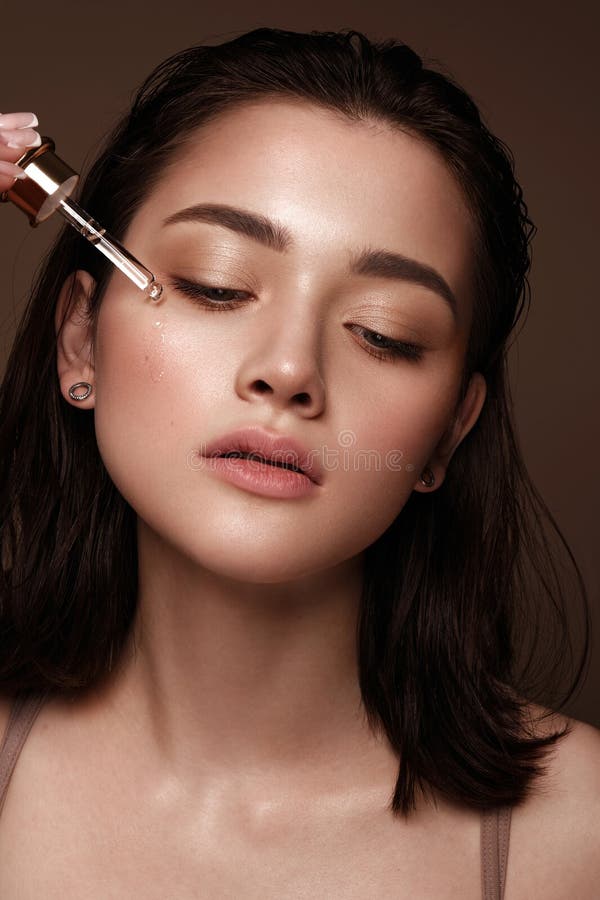 Beautiful Young Girl With Natural Nude Make Up With Cosmetics Oil In Hands Beauty Face Stock 9146