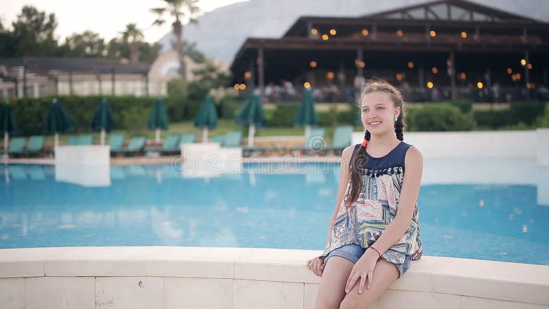 Beautiful Young Girl Sitting by the Pool Stock Video - Video of girl ...