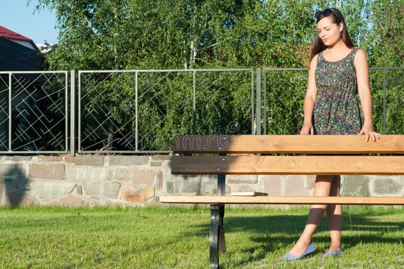 Beautiful Young Lady Posing in Park Standing beside Bench Stock Photo ...