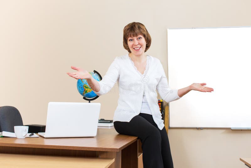 Beautiful Young Teacher Sitting on a Table in the Classroom Stock Photo ...
