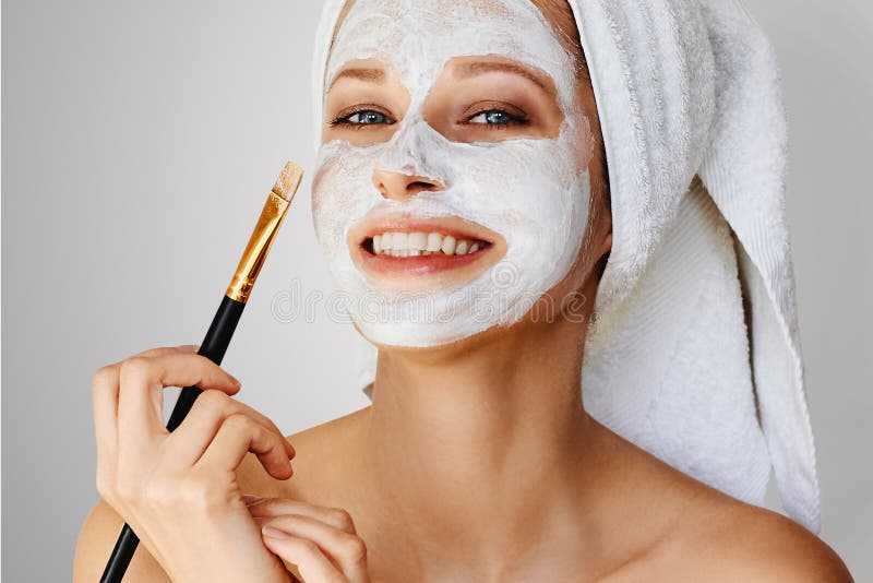 Beautiful Young Woman Applying Facial Mask On Her Face With Brush Skin