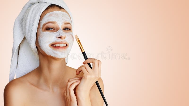 Beautiful Young Woman Applying Facial Mask On Her Face With Brush Skin