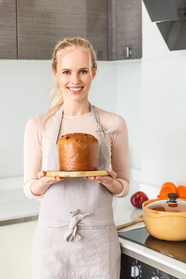 Beautiful Young Woman in Apron Holding Delicious Easter Cake and ... Beautiful Young Woman in Apron Holding Delicious Easter Cake and ...