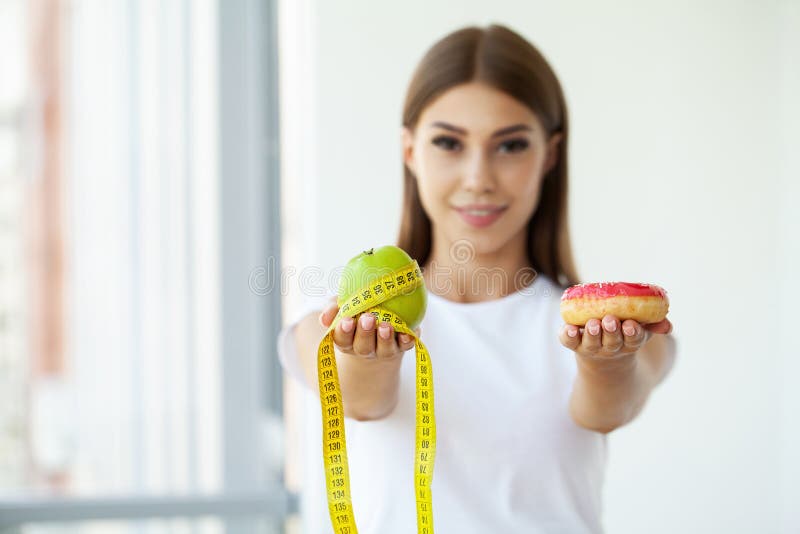 Beautiful Young Woman Choosing Between Healthy Food And Junk Food