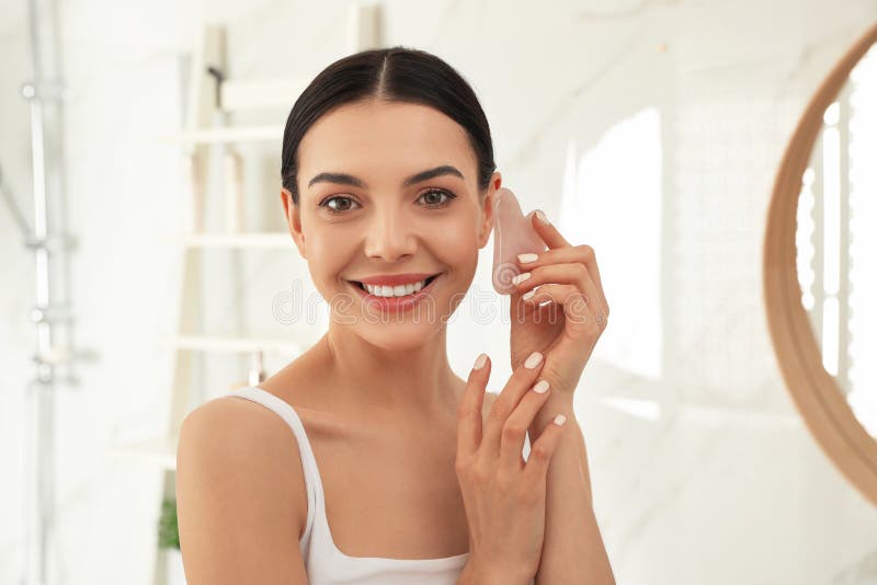Beautiful Young Woman Doing Facial Massage With Gua Sha Tool In