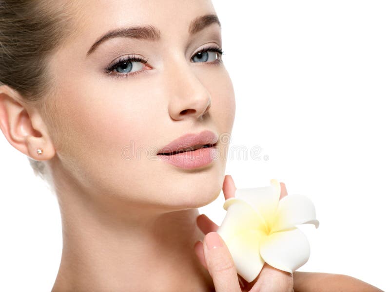 Beautiful Young Woman With Flower In Hand Near At Face Stock Image