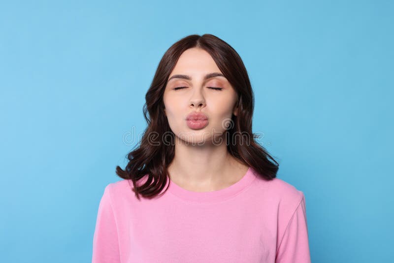 Beautiful Young Woman Giving Kiss on Light Blue Background Stock Photo ... Beautiful Young Woman Giving Kiss on Light Blue Background Stock Photo ...
