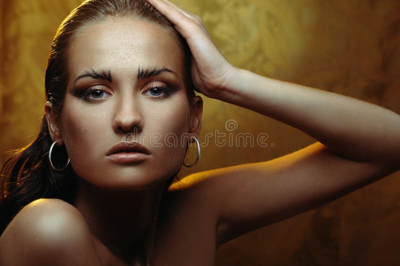 Beautiful Young Woman with Gold Makeup and Bronze Skin Stock Photo ...