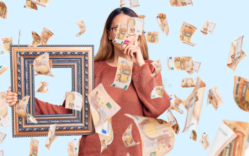 Beautiful Young Woman Holding Empty Frame Serious Face Thinking about ...