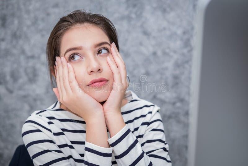 Beautiful Young Woman Looking at a Computer Screen and Thinking Stock ...
