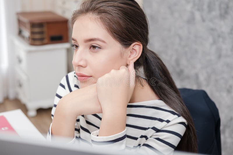 Beautiful Young Woman Looking at a Computer Screen and Thinking Stock ...