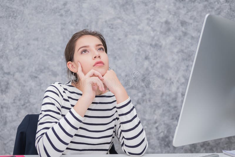 Beautiful Young Woman Looking at a Computer Screen and Thinking at the ...