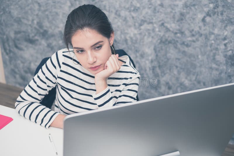 Beautiful Young Woman Looking at a Computer Screen and Thinking at the ...