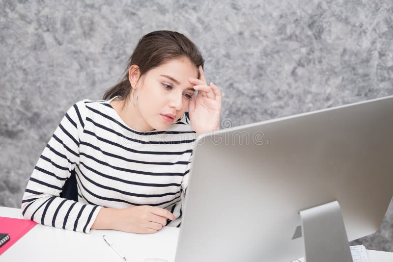 Beautiful Young Woman Looking at a Computer Screen and Thinking at the ...