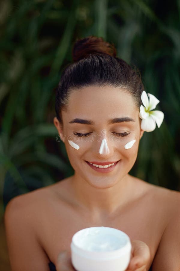 Beautiful Young Woman With Moisturizing Cream On Face Girl Holding