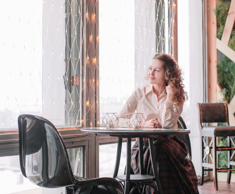 Cute Young Woman Sitting at a Table in a Cafe Stock Photo - Image of ...