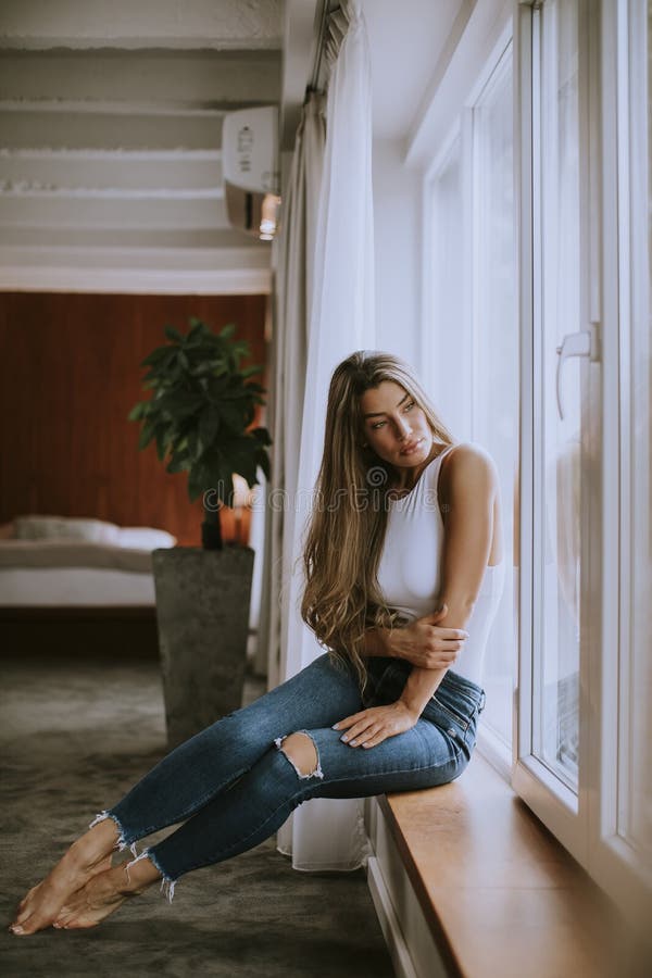 Beautiful Young Woman Sitting by the Window Stock Photo - Image of ...