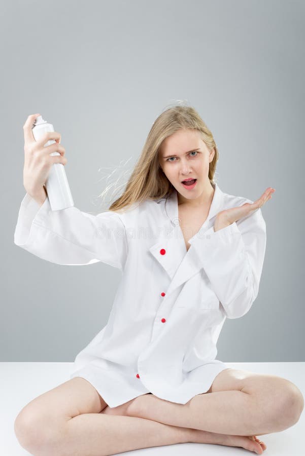 A Beautiful Young Woman Smiling while Using a Hairspray Stock Photo ...