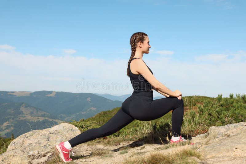 Beautiful Young Woman Stretching on Rock in Mountains Stock Photo ...