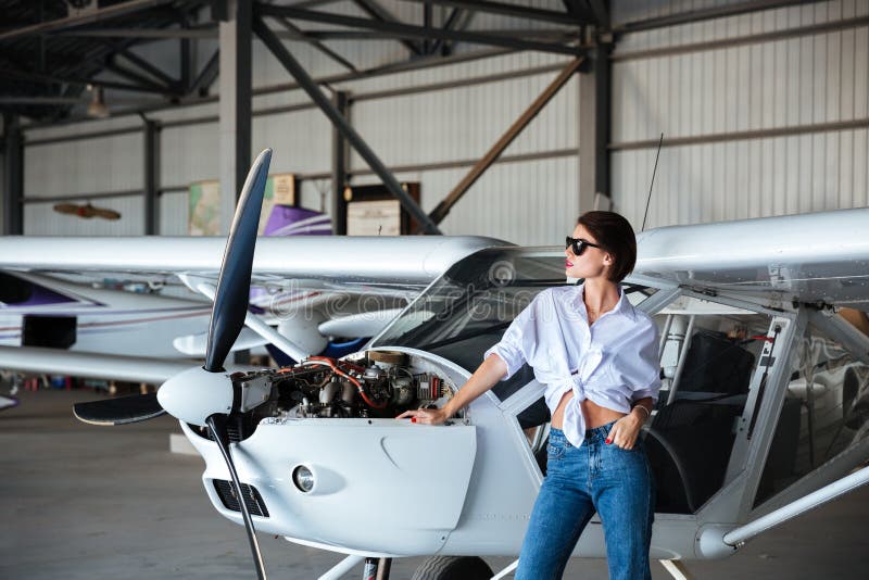 Beautiful Young Woman in Sunglasses Posing Near Plane in Angar Stock ...