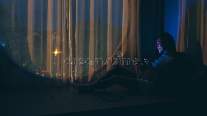 A Young Woman Using Mobile Phone with Bright Light Screen in the Late ...