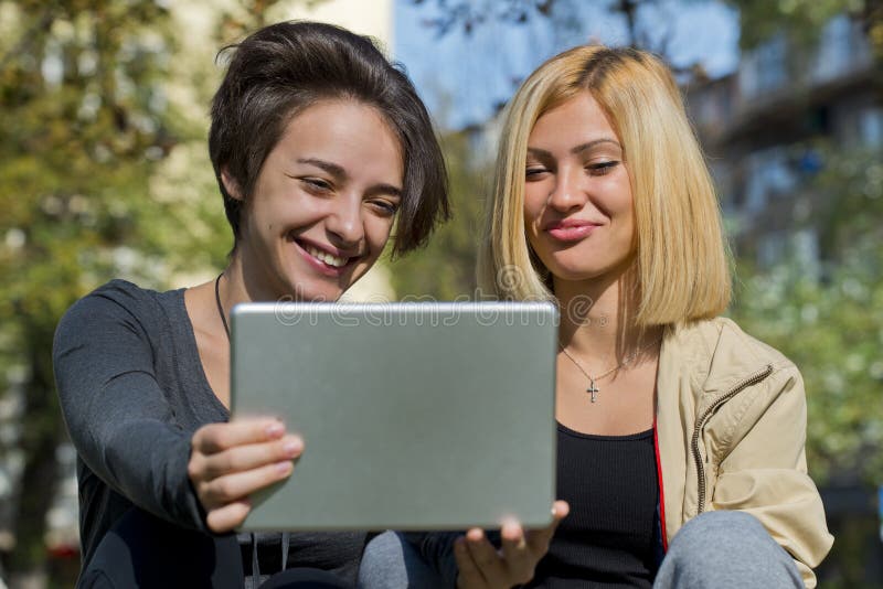 Beautiful Young Women Using Tablet Outside. Stock Image - Image of ...