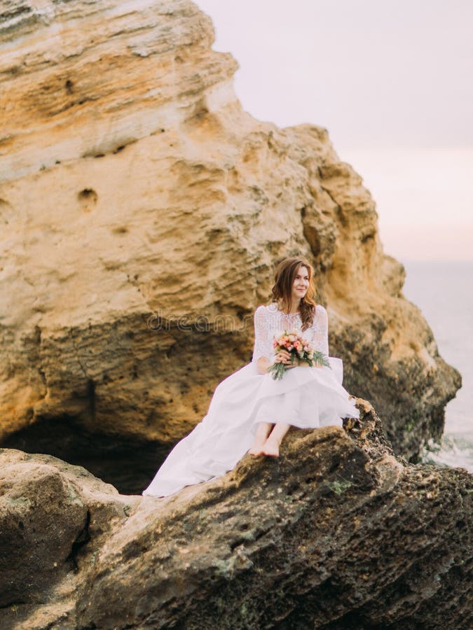 Beautifully Dressed Bride with the Wedding Bouquet is Sitting on the ...