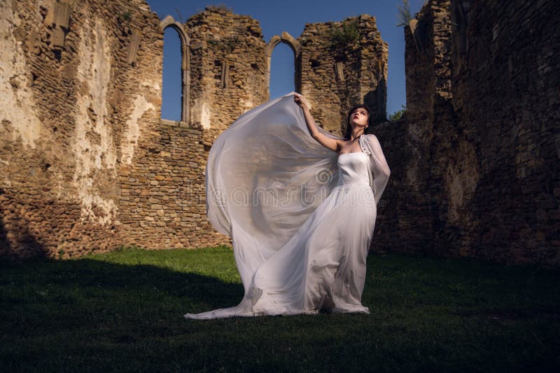 Beauty Bride Model in Wedding Dress Flying on Wind in Front of the ...