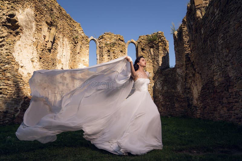 Beauty Bride Model in Wedding Dress Flying on Wind in Front of the ...
